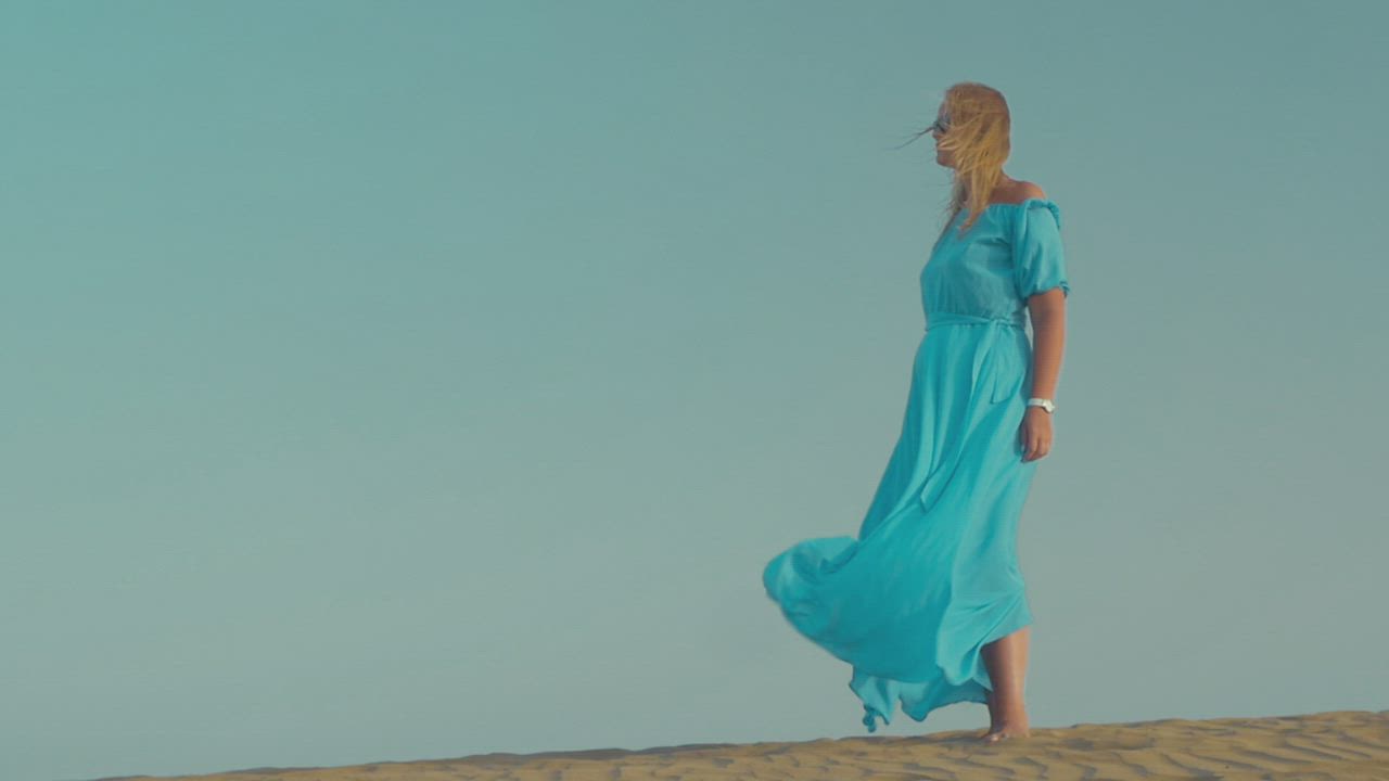 Woman standing still in a blue dress - Free Stock Video