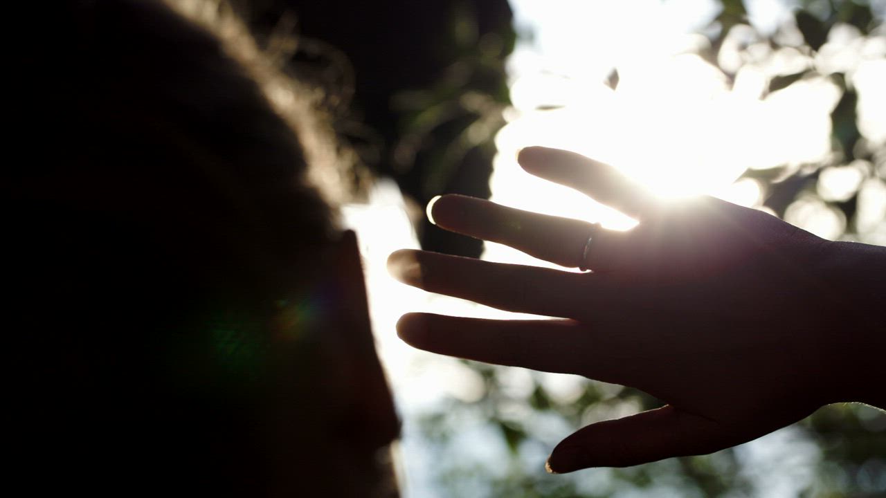 Woman holding up her hand to block the sun - Free Stock Video