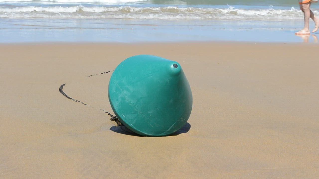 Buoy washed up on the beach - Free Stock Video