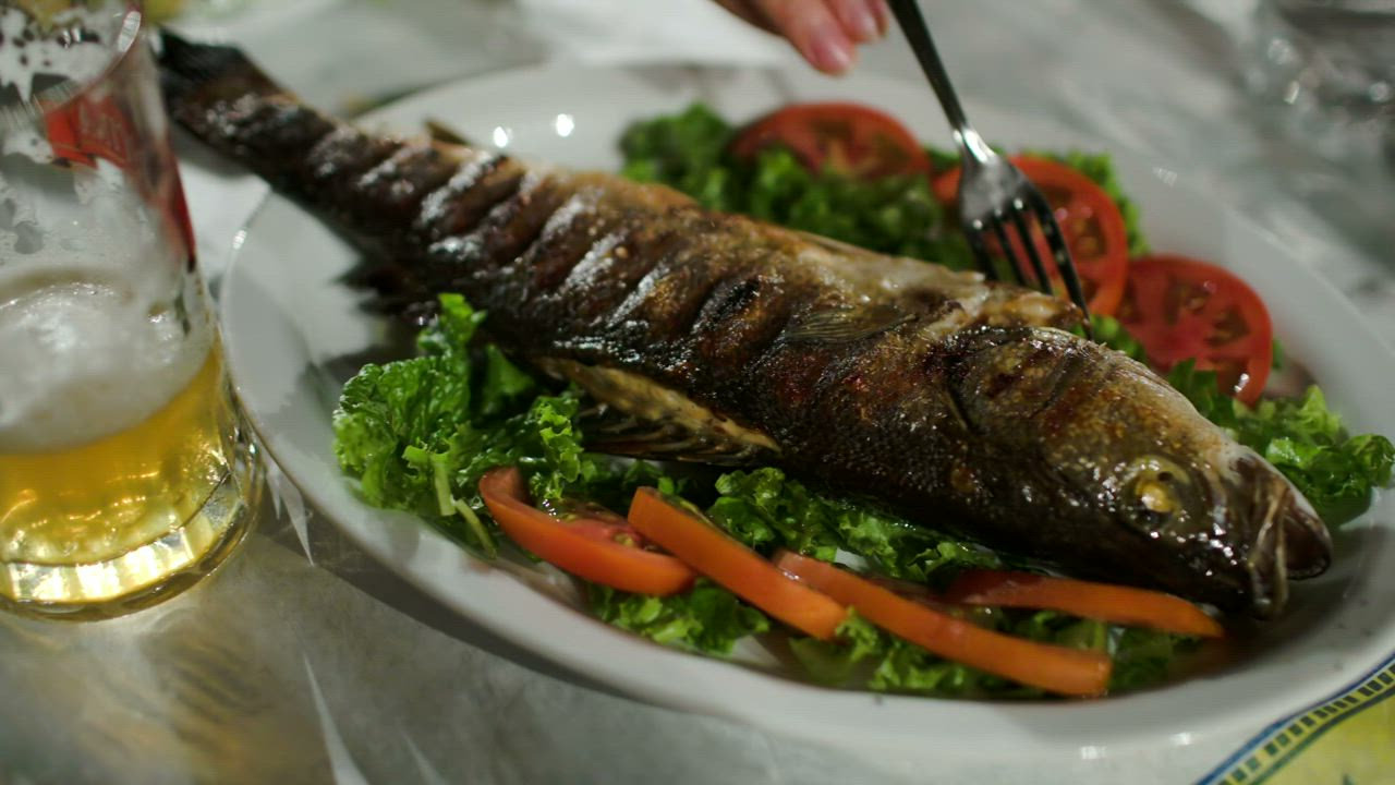 Pouring a sauce on cooked fish - Free Stock Video