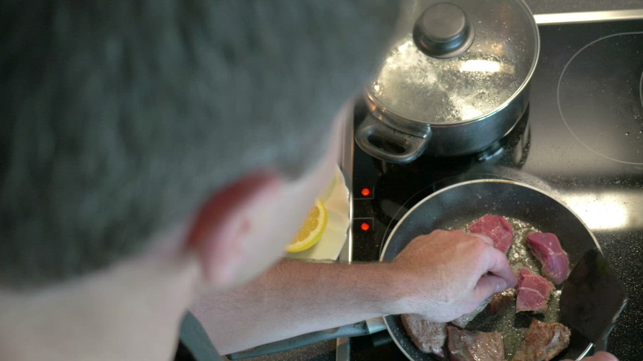 Man preparing beef in a frying pan - Free Stock Video