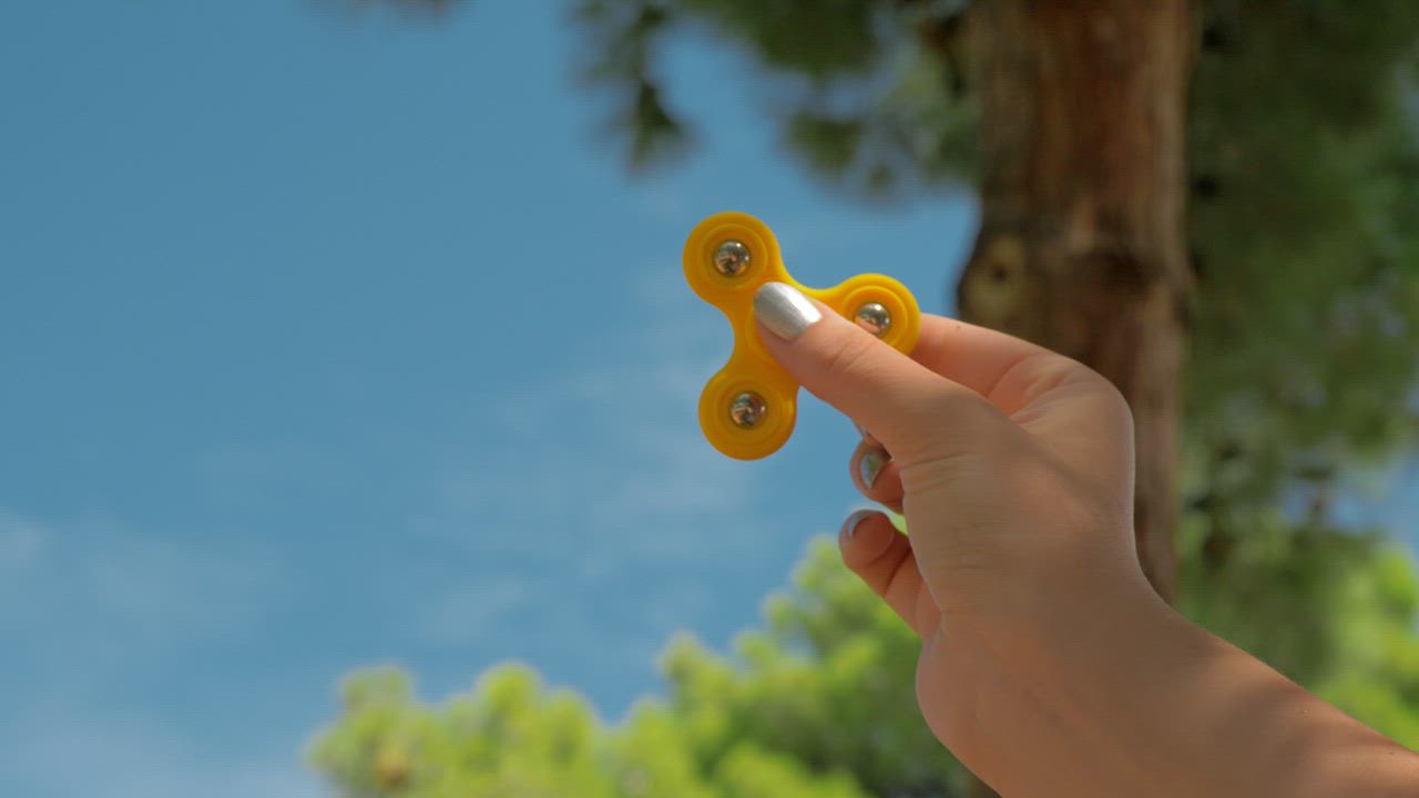 Playing with a Fidget Spinner - Free Stock Video