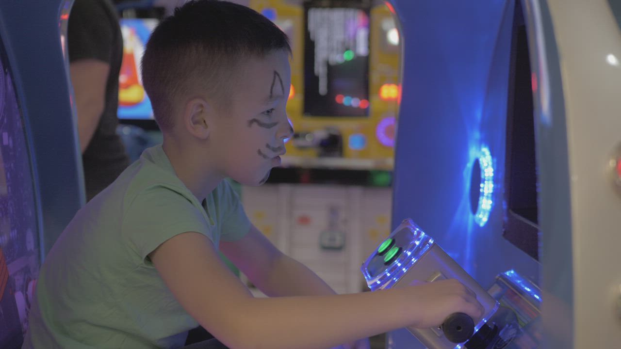 Boy playing on an arcade machine - Free Stock Video