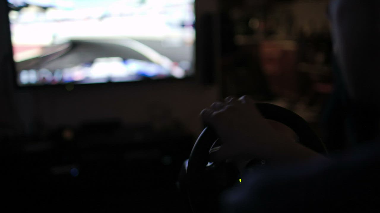 Playing a racing game with a wheel - Free Stock Video