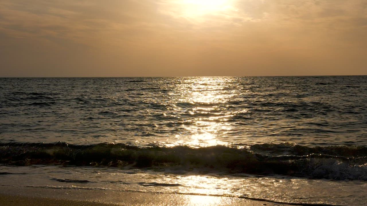 Slow waves and a golden sunset - Free Stock Video