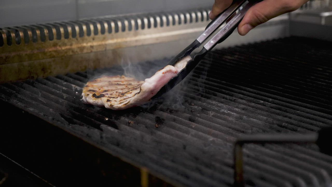 Turning chicken over on the grill - Free Stock Video