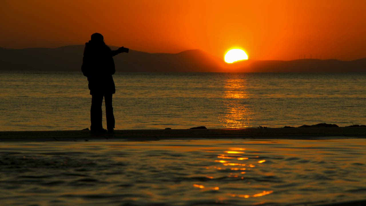 Lovers taking a selfie at sunset on the seashore - Free Stock Video