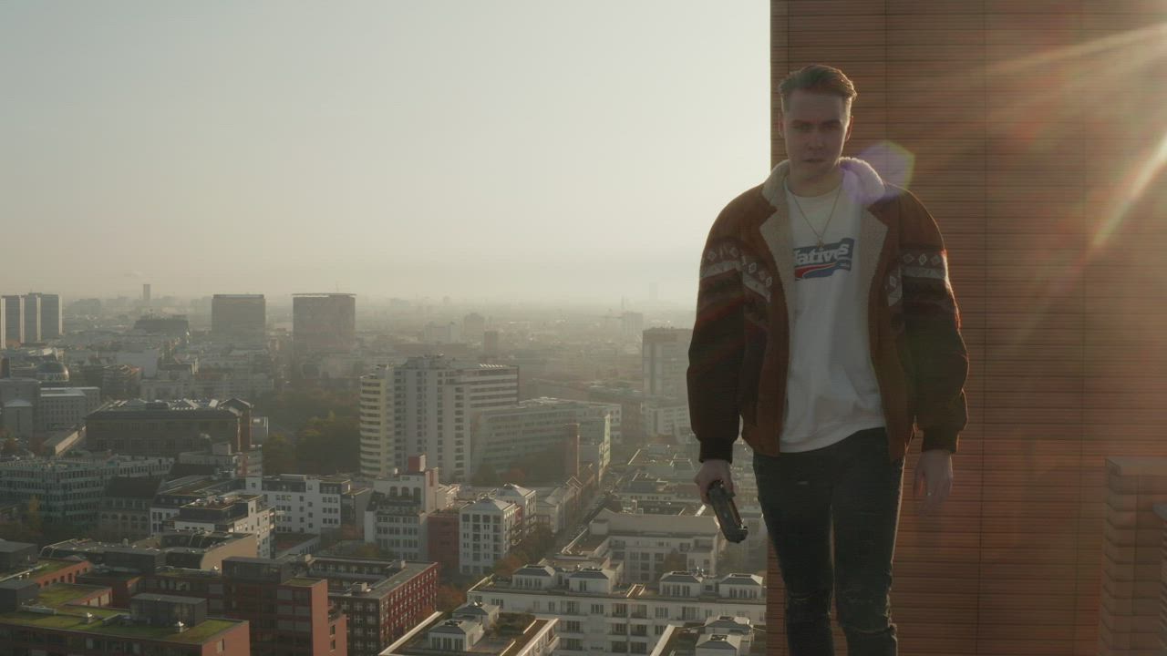 Young man standing on the rooftop of a building - Free Stock Video