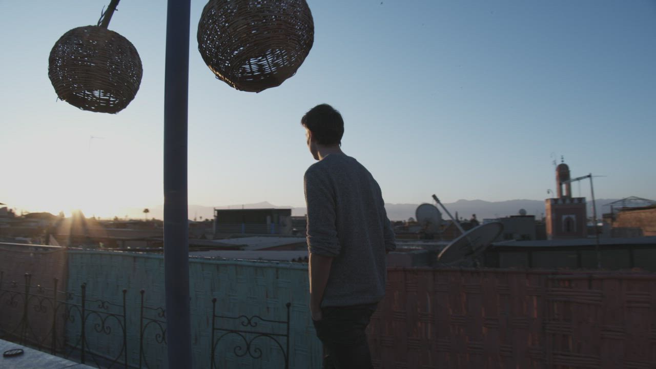 Man walks on the rooftop with sunrise view - Free Stock Video