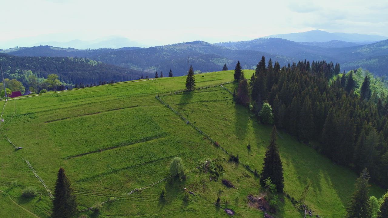 Field of a farm with a view of the mountains - Free Stock Video