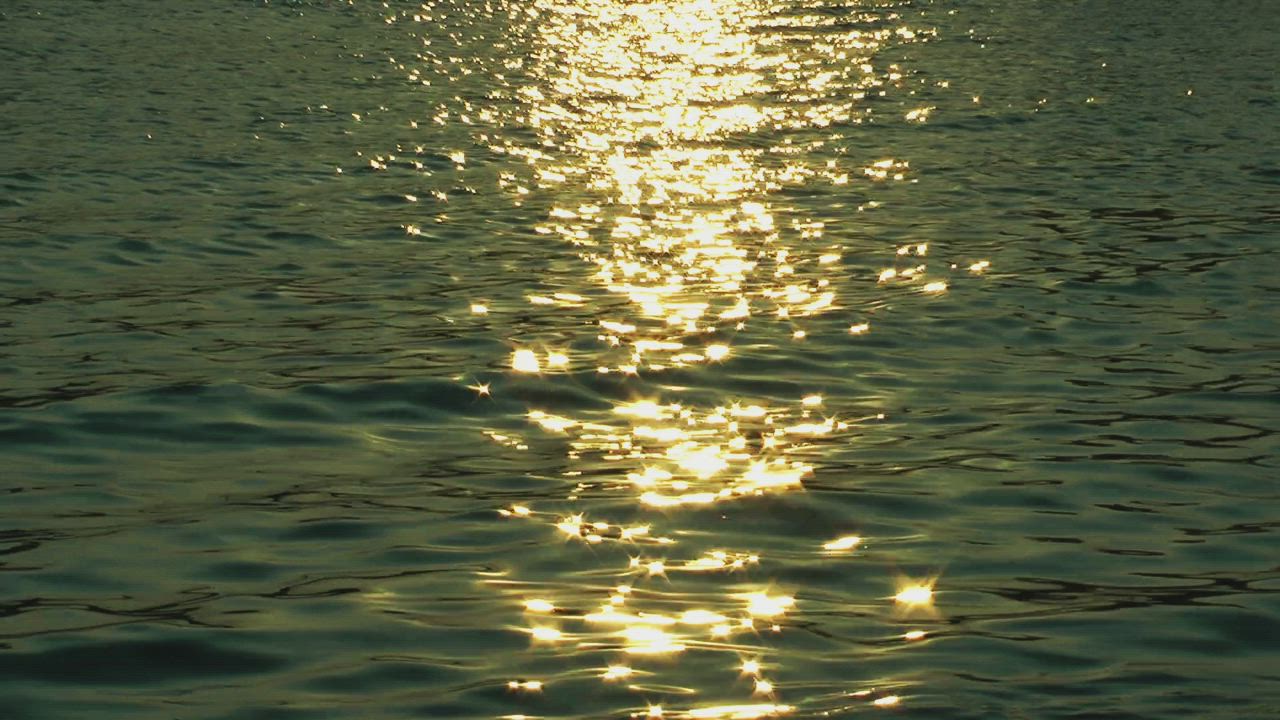 Sea water reflecting the light of the sunset - Free Stock Video