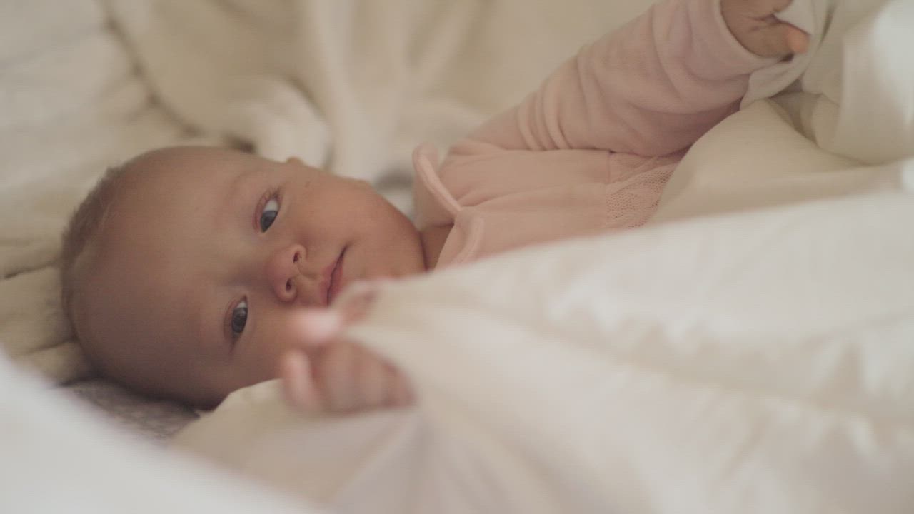 Young baby moving their bedding - Free Stock Video
