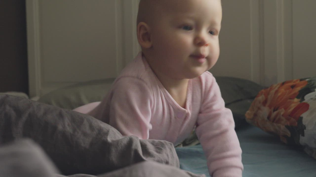 Restless baby smiling at the camera - Free Stock Video