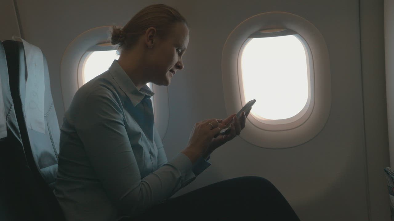 Woman using her phone during a flight - Free Stock Video