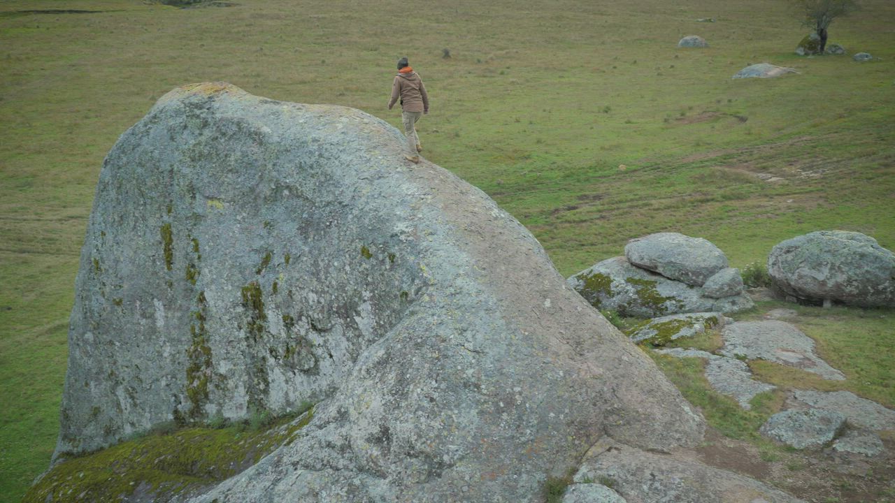 Man walking on a giant stone - Free Stock Video