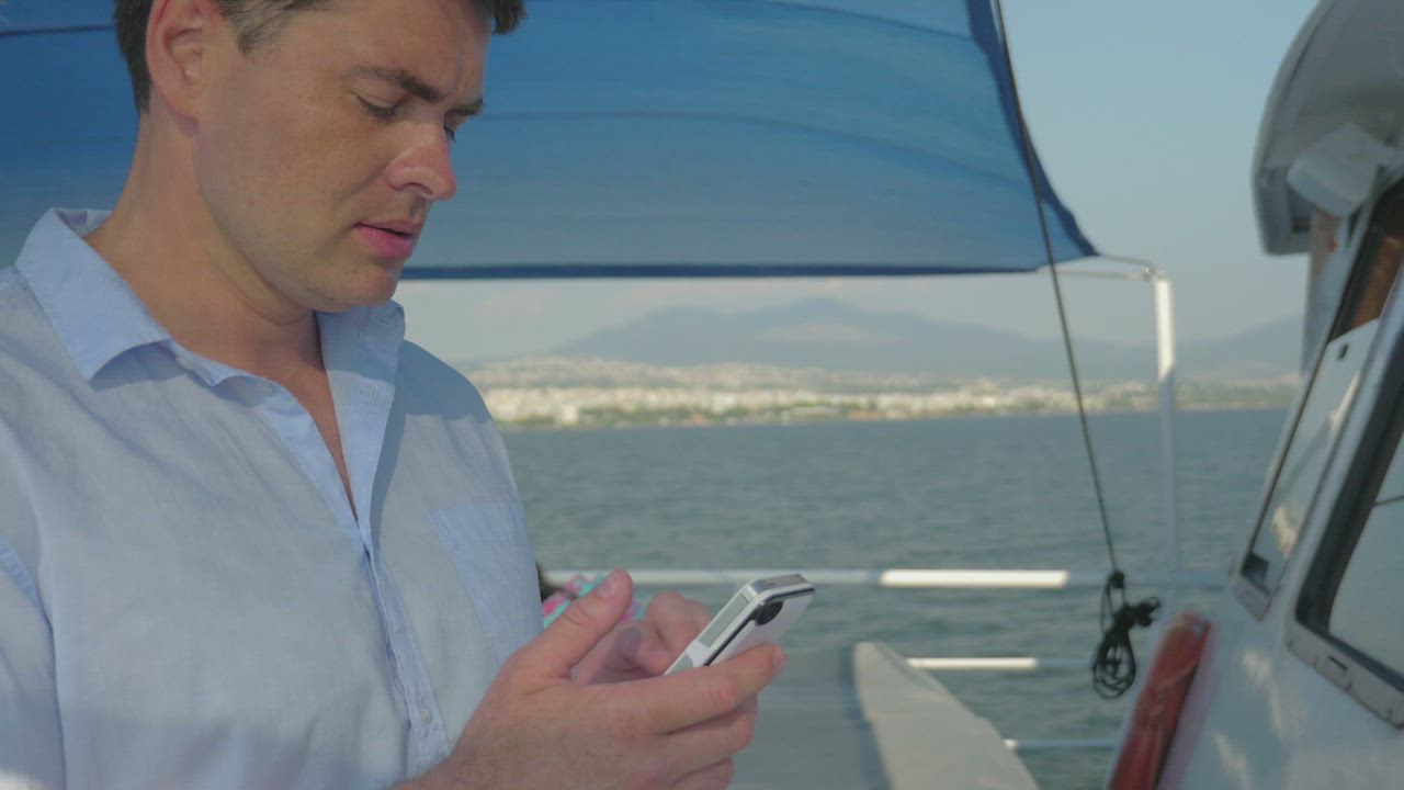 Texting while out on a boat - Free Stock Video