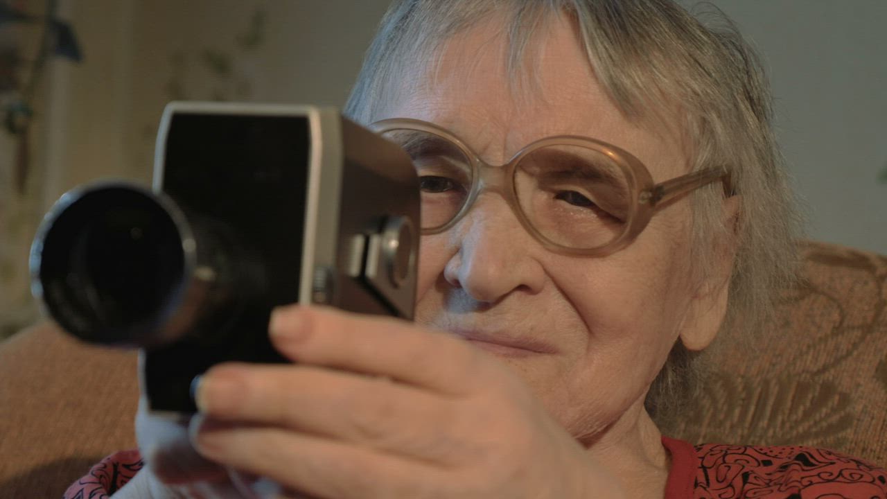 Woman using a retro camera inside - Free Stock Video