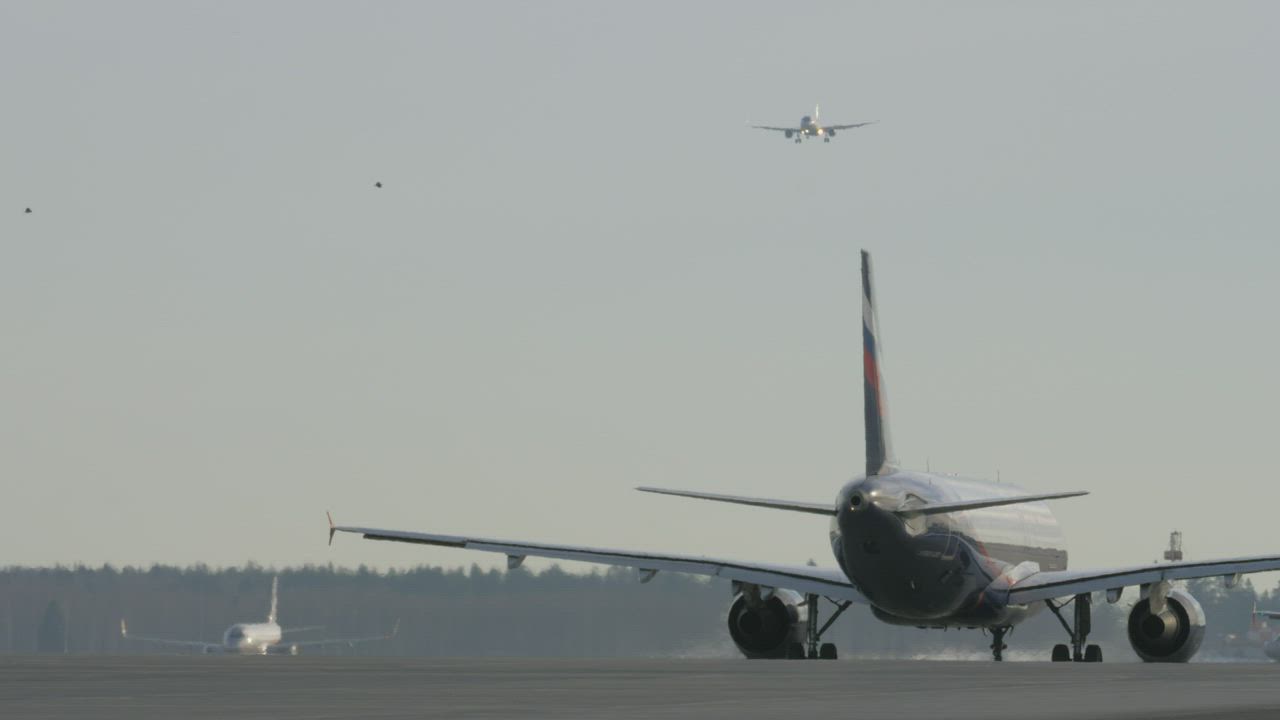 Plane landing while another moves to take off - Free Stock Video
