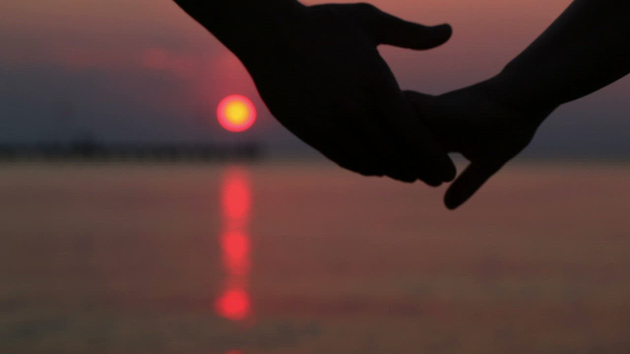 Holding hands during a dark sunset - Free Stock Video