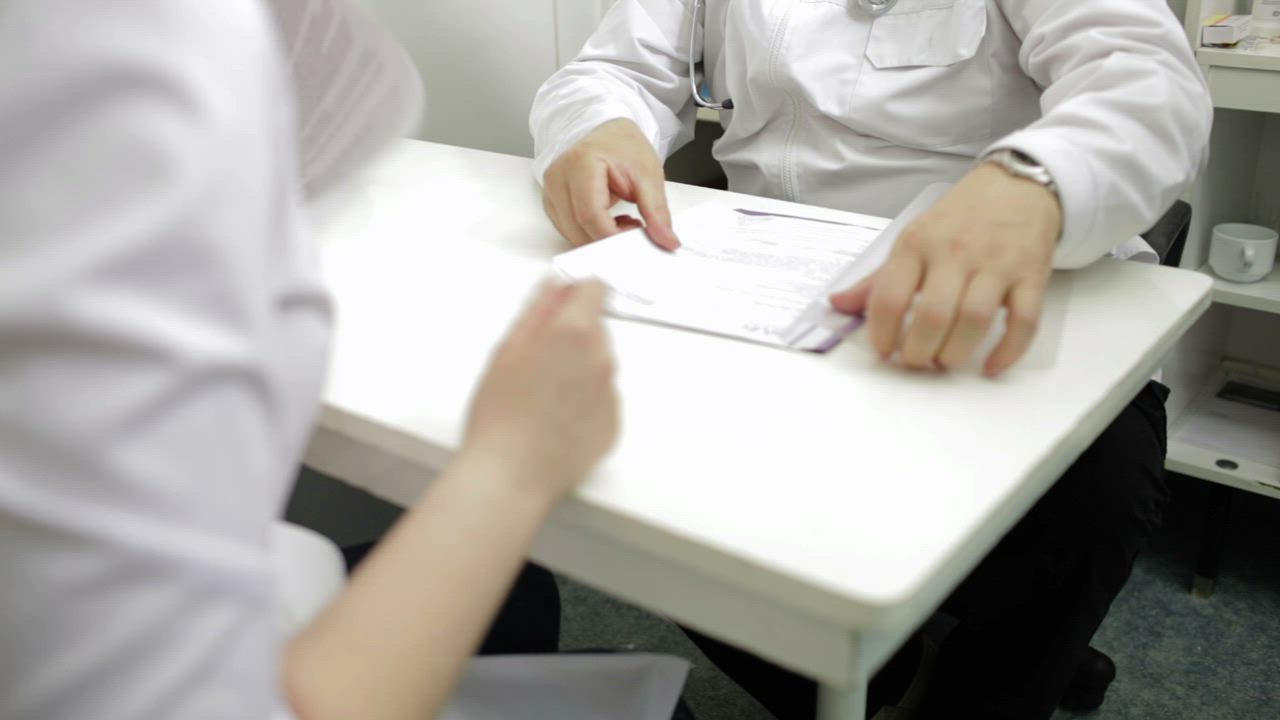 Doctor looking over patient treatment - Free Stock Video
