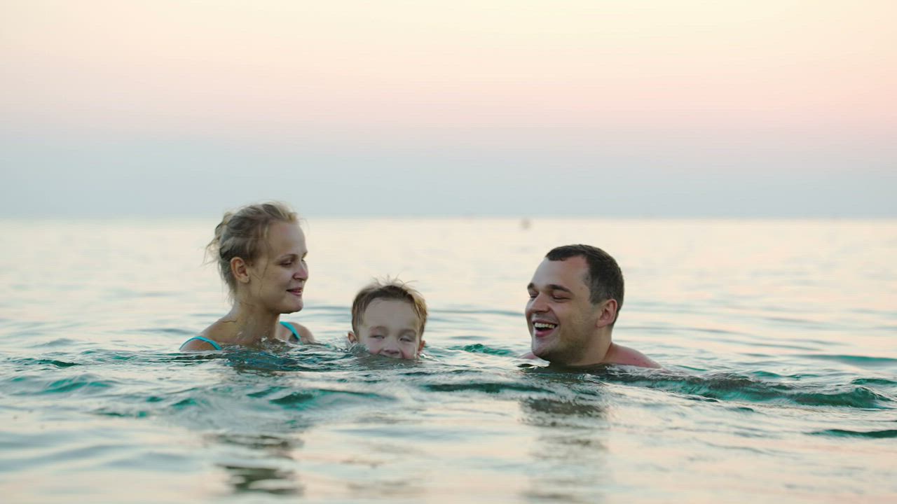 Young parents playing in the ocean - Free Stock Video