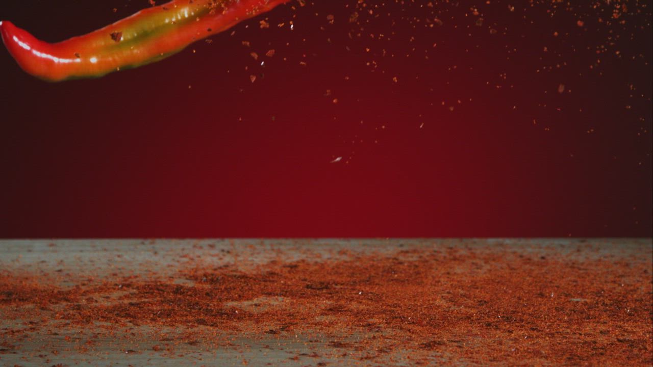 Peppers and red powder falling to the table - Free Stock Video