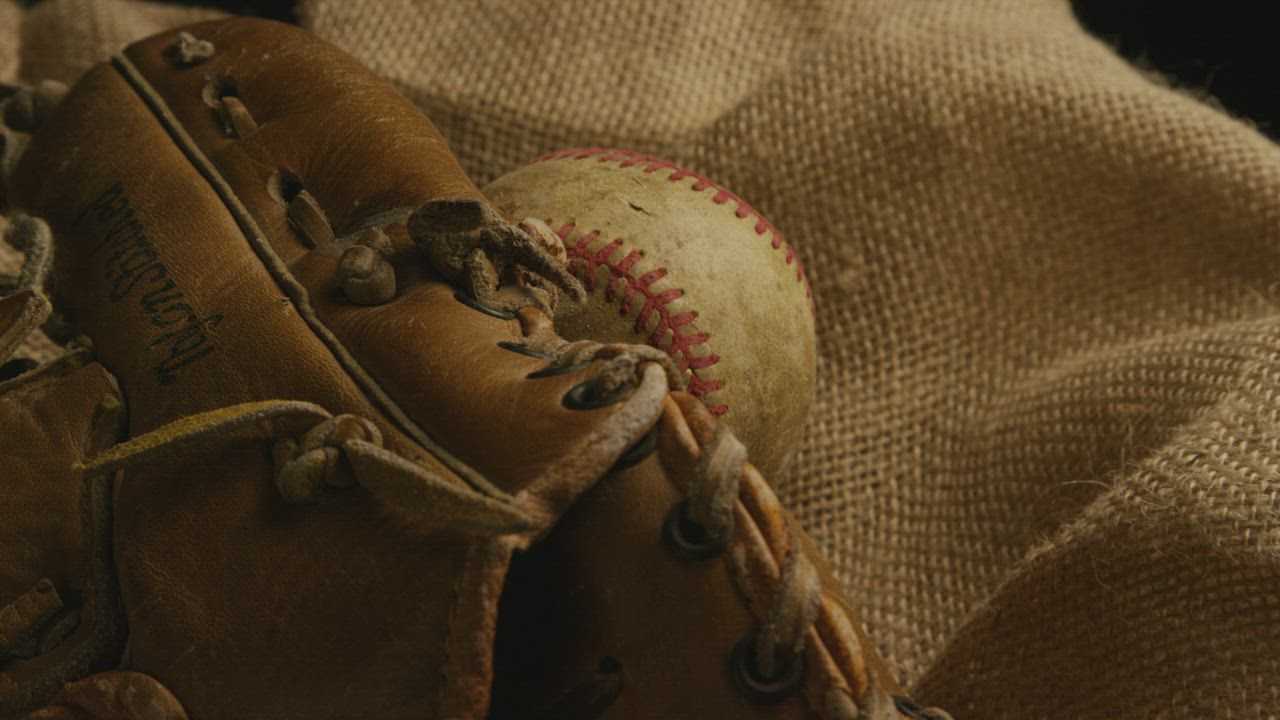 Baseball glove and a used ball over a fabric - Free Stock Video