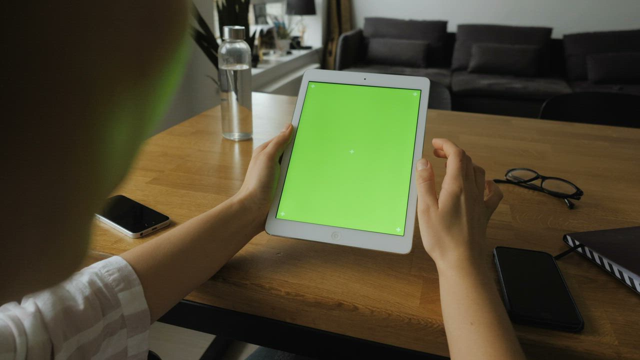 Woman using a tablet with a green screen - Free Stock Video