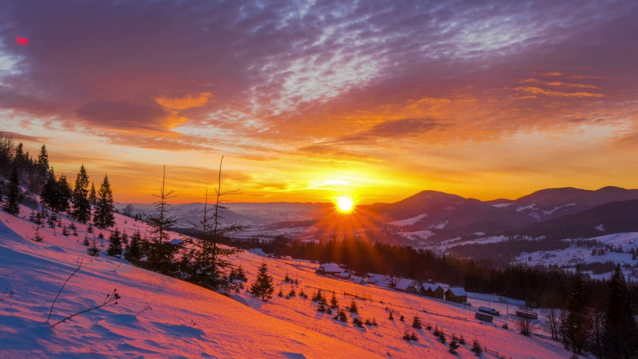 Sunset over a snowy winter mountain - Free Stock Video
