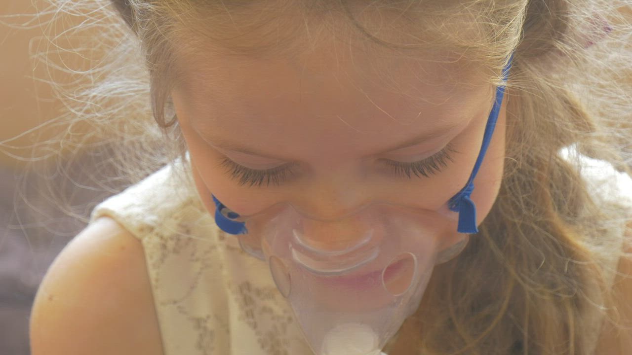 Little girl breathing with a facemask - Free Stock Video