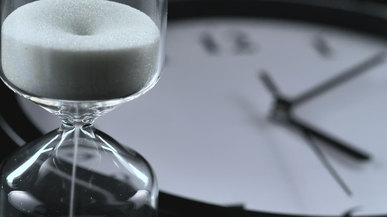 An hourglass and an analog wall clock - Free Stock Video