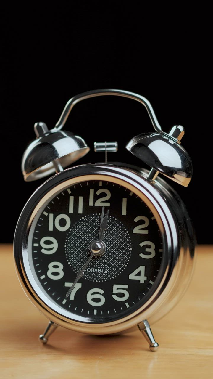 Alarm clock ringing on a wooden table - Free Stock Video