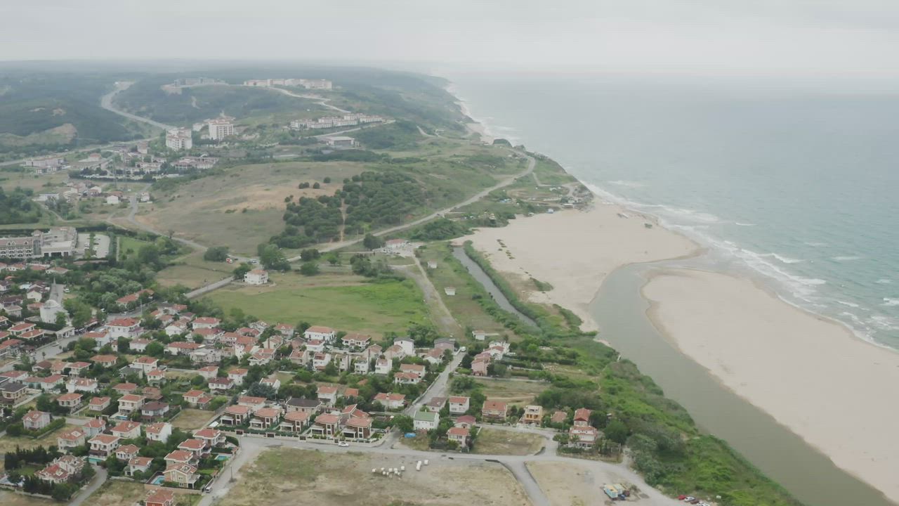 Empty beach at the edge of a town - Free Stock Video