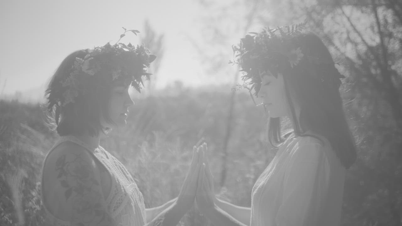 Couple of women performing a small ritual with their hands together ...