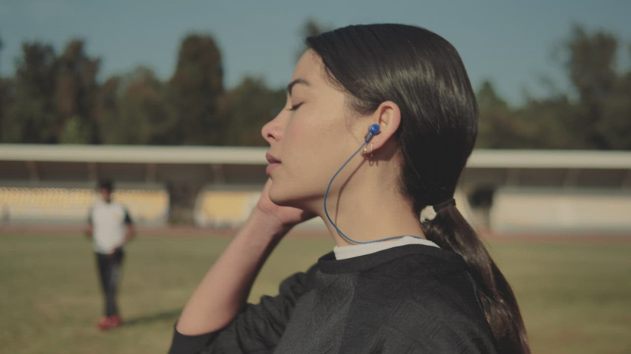 Woman taking off her headphones while walking - Free Stock Video