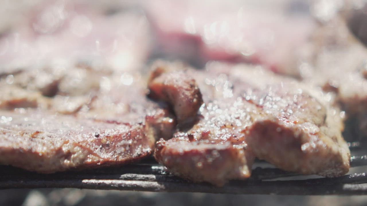 Person cooking meat on a grill - Free Stock Video