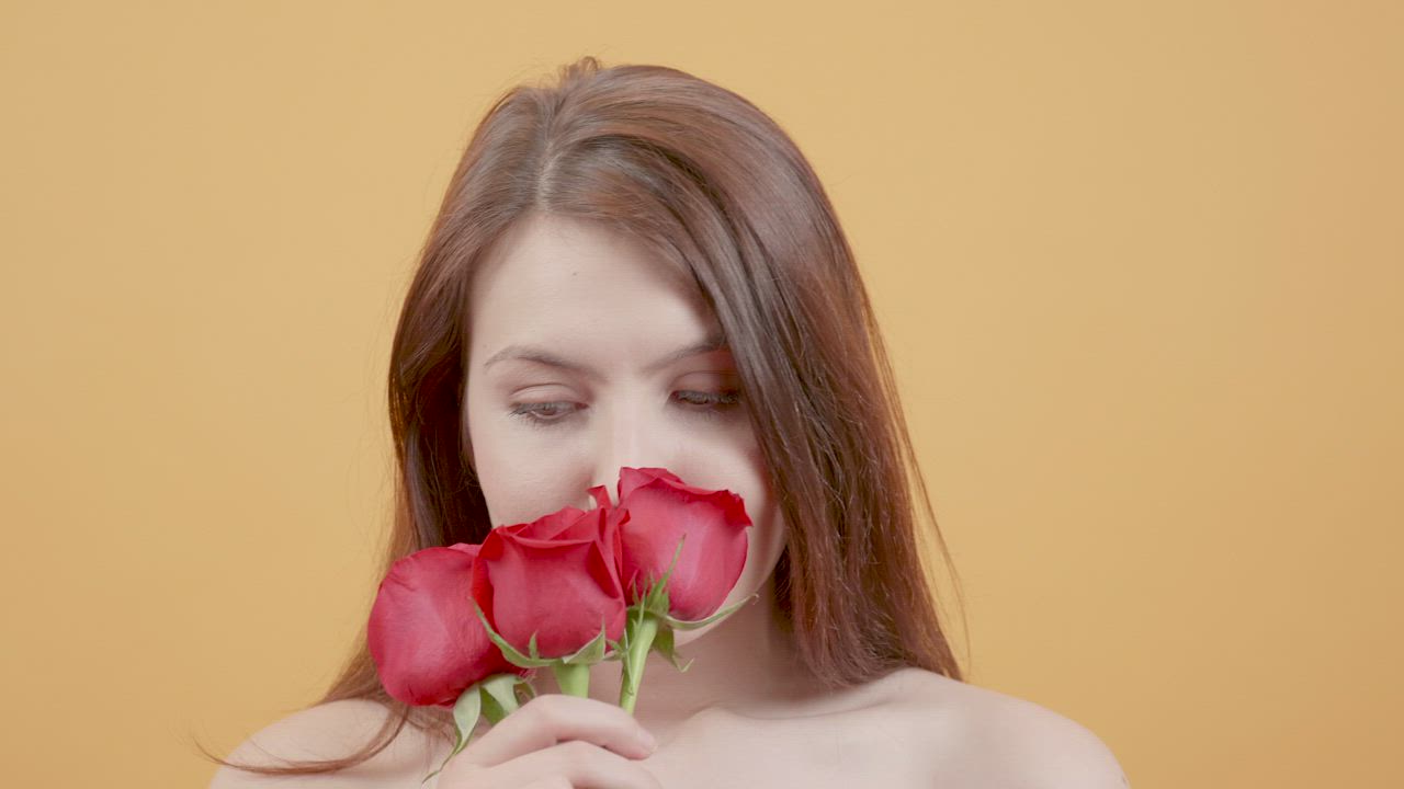 Portrait of young woman smelling red roses - Free Stock Video
