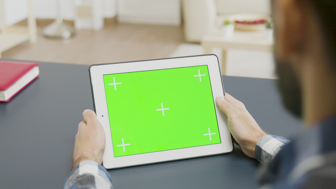 Man looking at a tablet with green screen - Free Stock Video