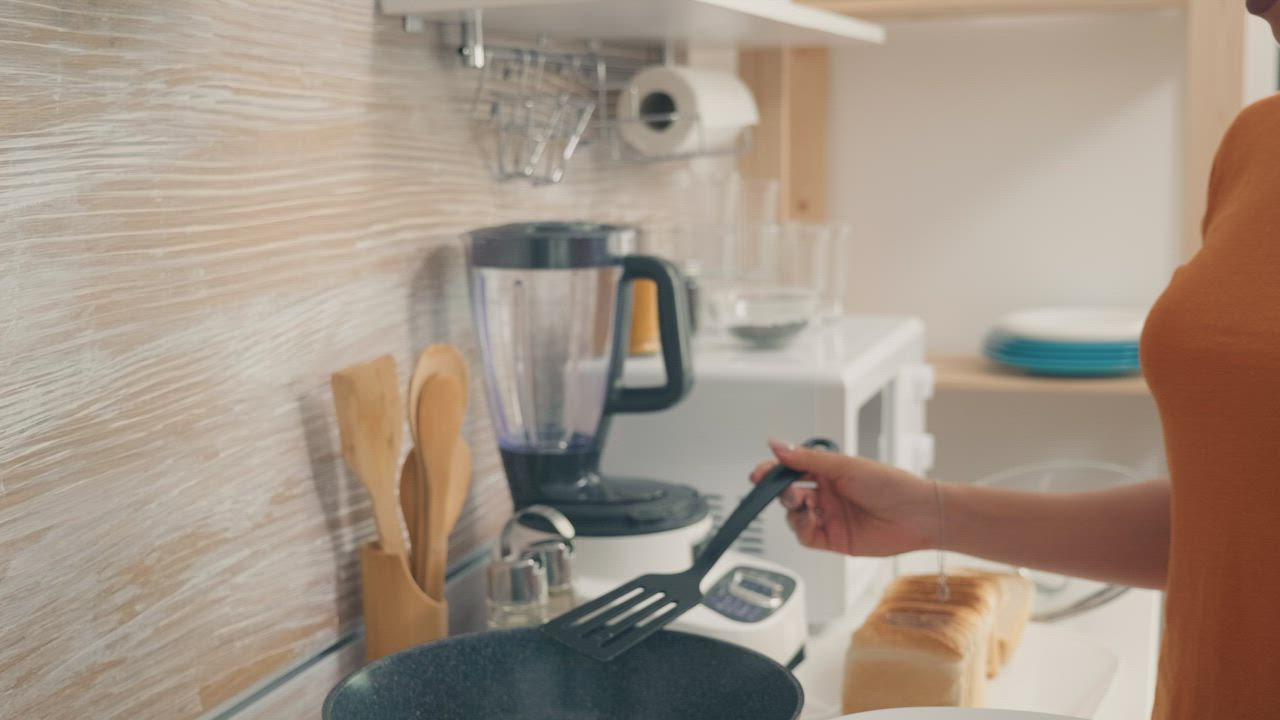 Housewife cooking breakfast in the kitchen - Free Stock Video