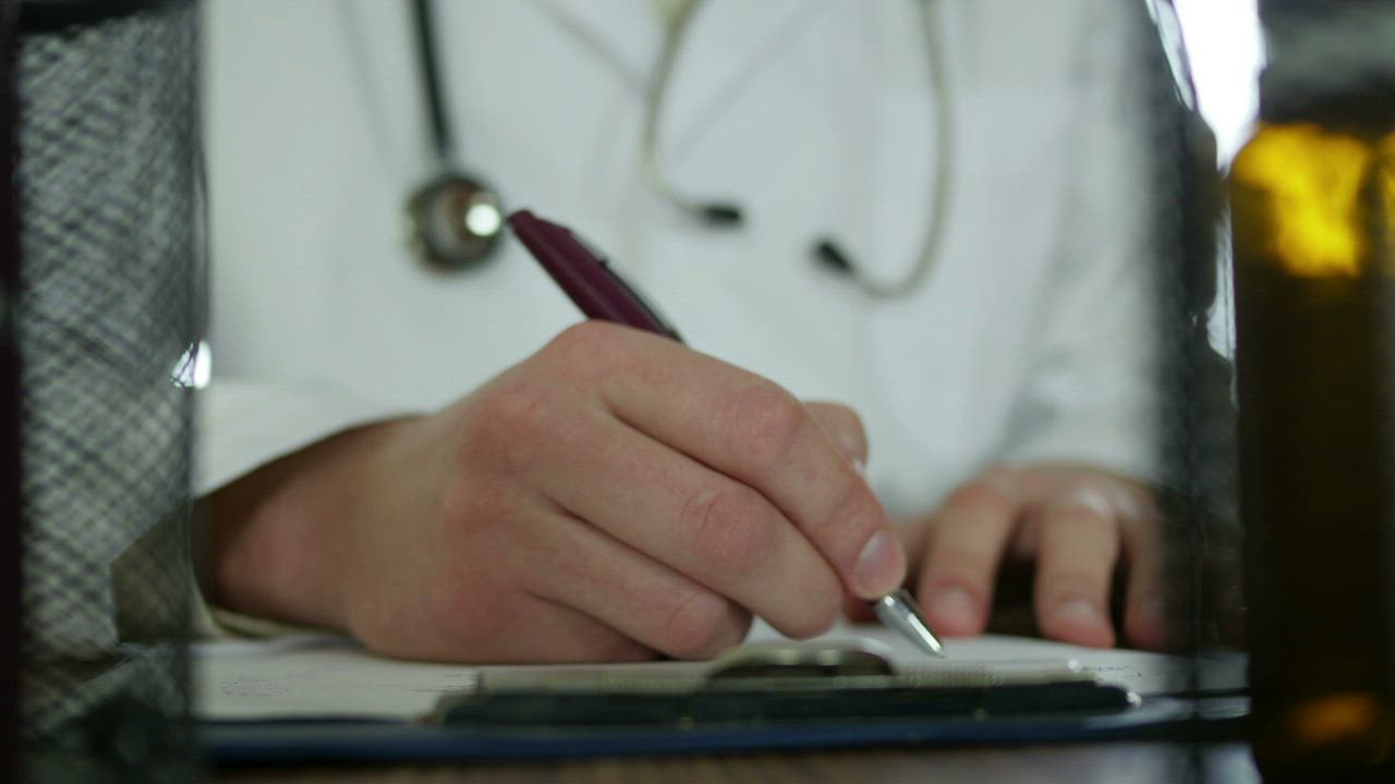 Doctor writing down a prescription - Free Stock Video