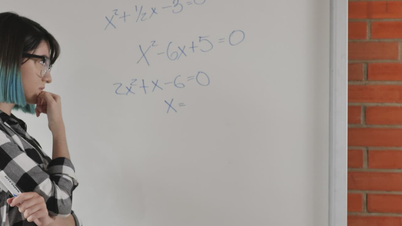 Student girl trying to solve equations on the whiteboard - Free Stock Video