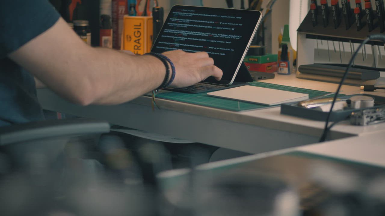 Young engineer programming in his workshop seen up close - Free Stock Video