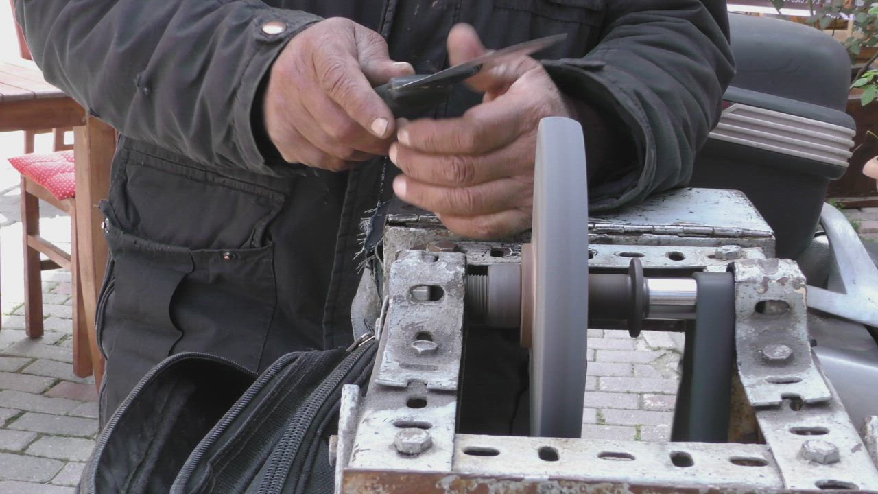 Worker sharpening his tool on a machine - Free Stock Video