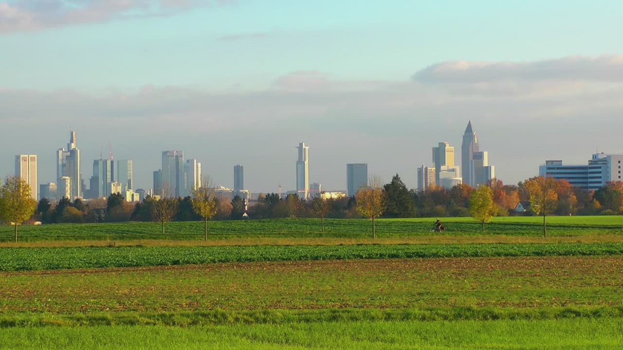 City buildings seen from fields in the countryside - Free Stock Video