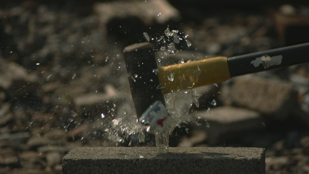 Smashing a glass bottle with a sledge - Free Stock Video