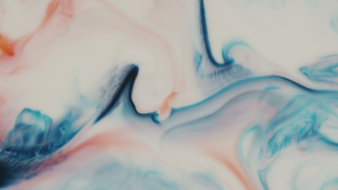 Red and blue fluid floating in a white liquid - Free Stock Video