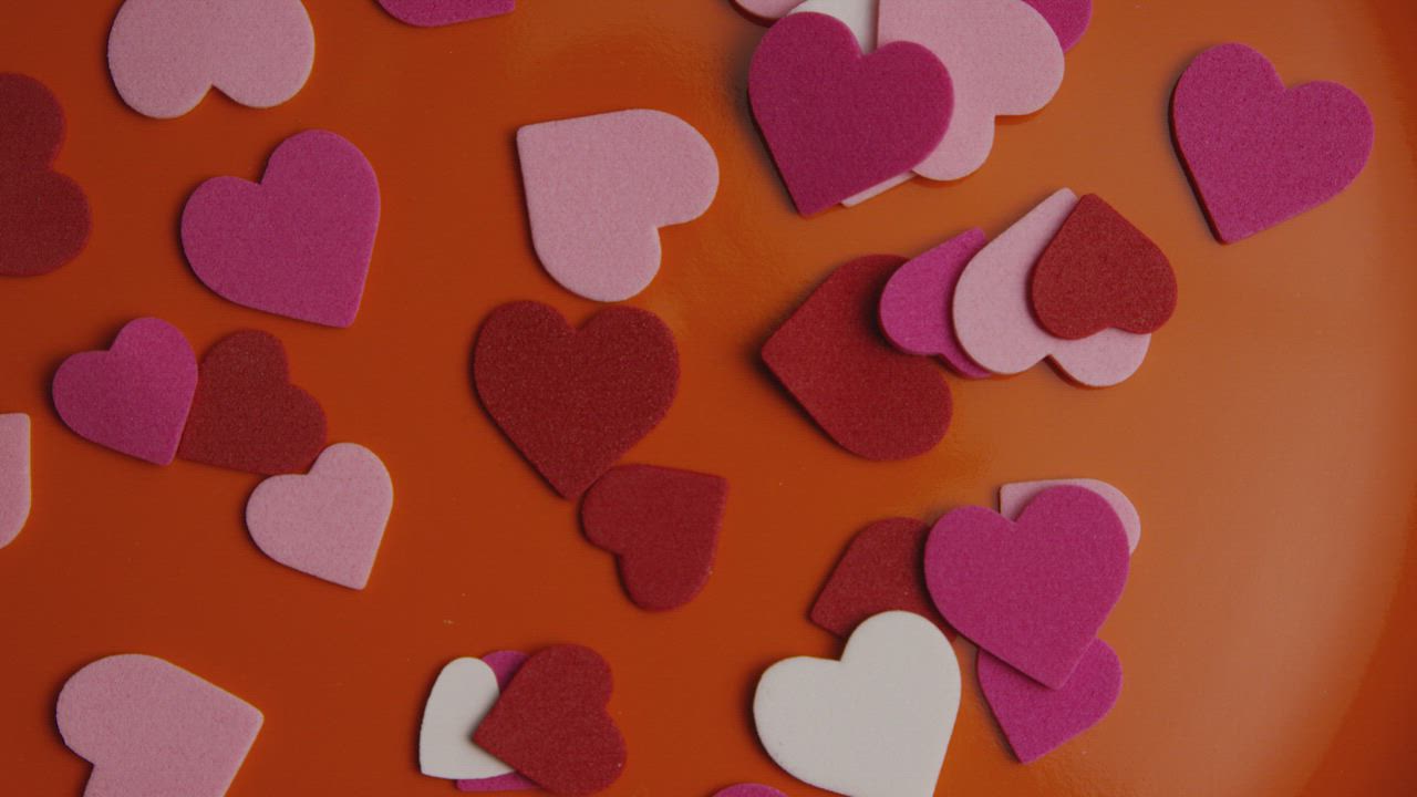 Paper shape hearts on an orange surface - Free Stock Video