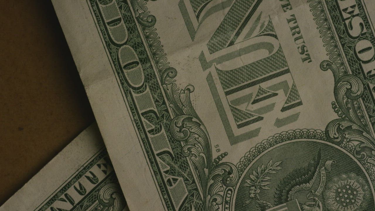 One dollar bills falling in to the table - Free Stock Video