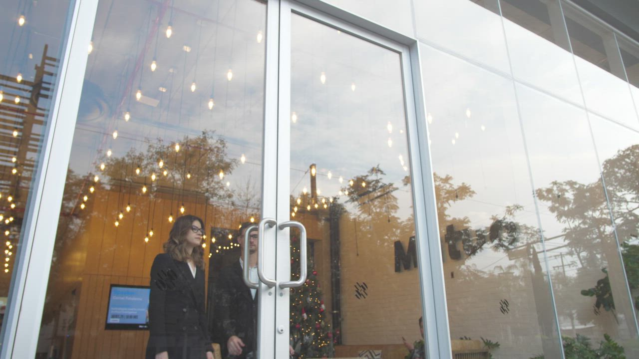 Two business people exit a building - Free Stock Video