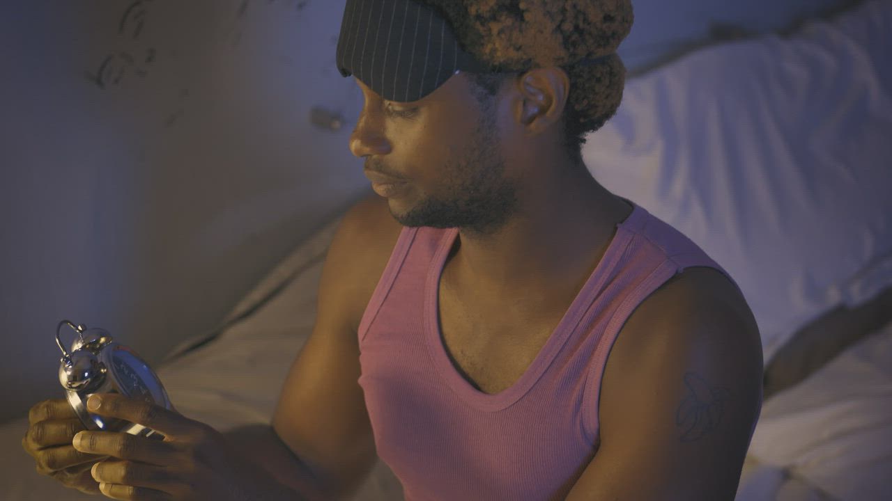 Man setting his alarm clock before going to sleep - Free Stock Video